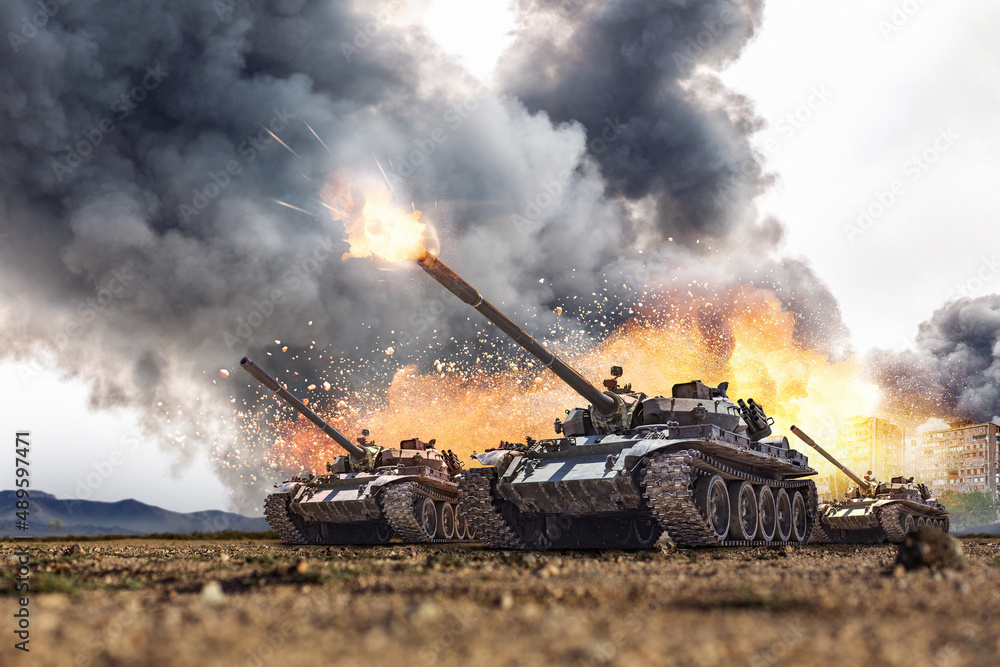 Group of main battle tanks with a city on fire on the background. One ...