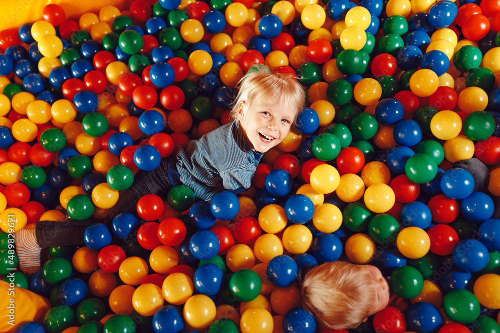 Happy Children Playing in a Ball Pit Pool in Amusement Park. Boys ...