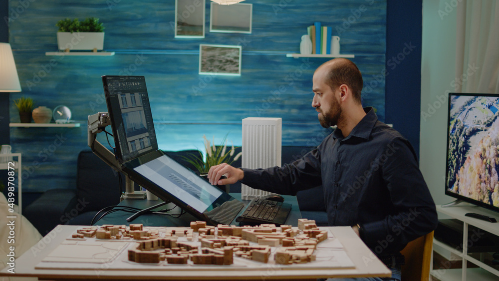 Architect analyzing building model on touch screen monitor for ...