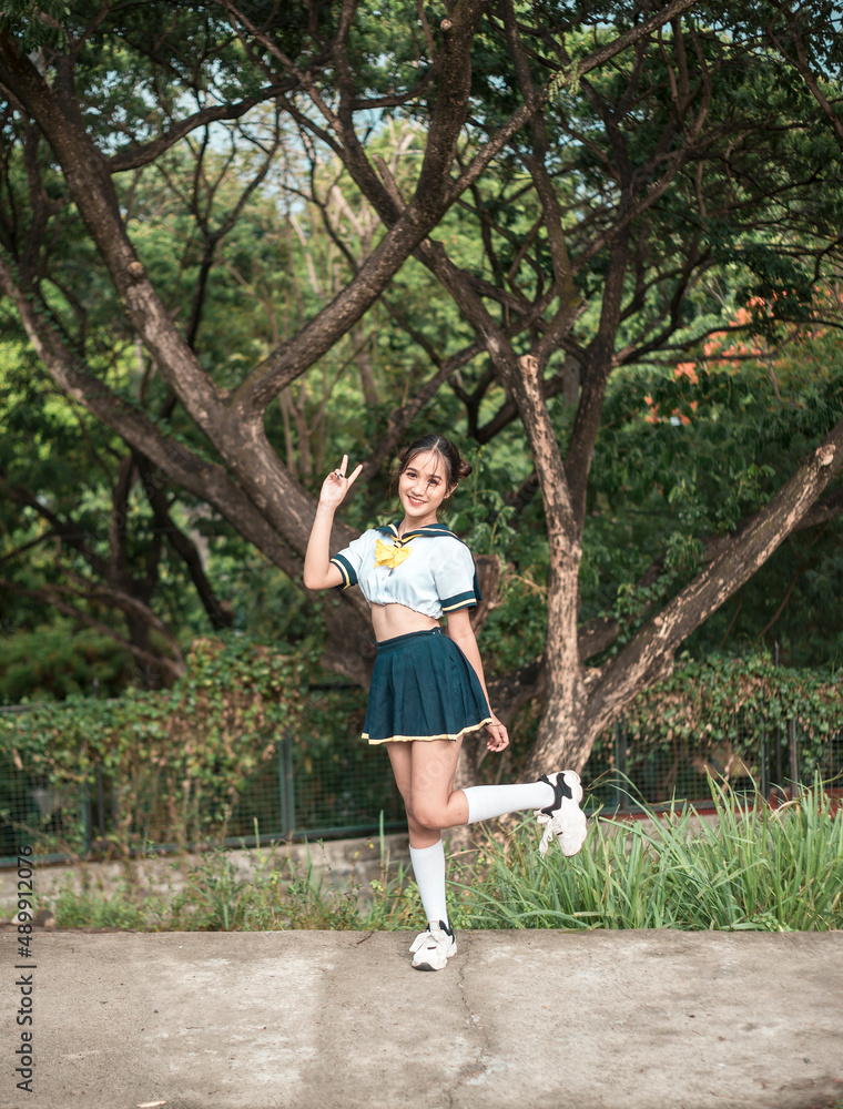 A confident teenage cosplayer in a cropped top, miniskirt and high ...