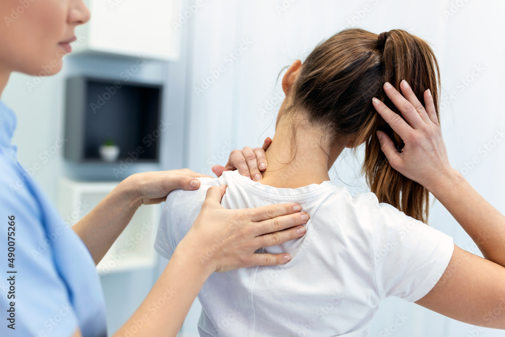 Woman doctor osteopath in medical uniform fixing woman patients ...