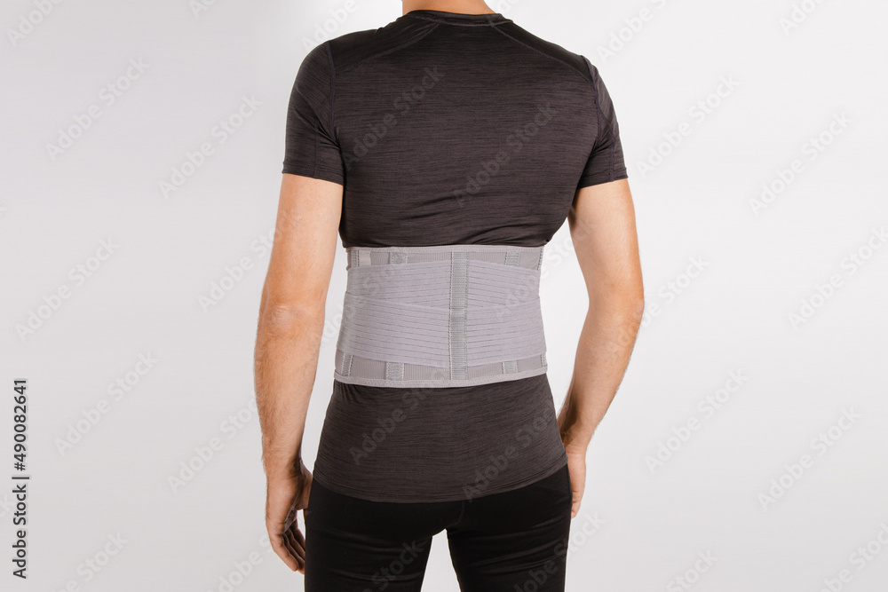 Lumbar brace on the human body isolated on a white background. Trauma ...