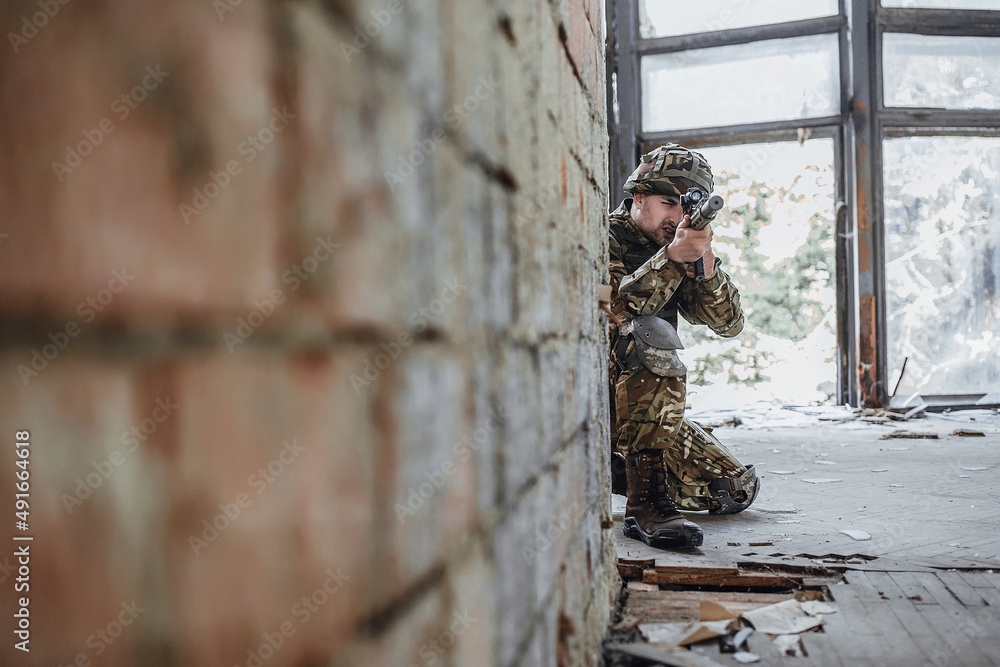 Strong military man in the form holds in hands a big rifle, looks like ...
