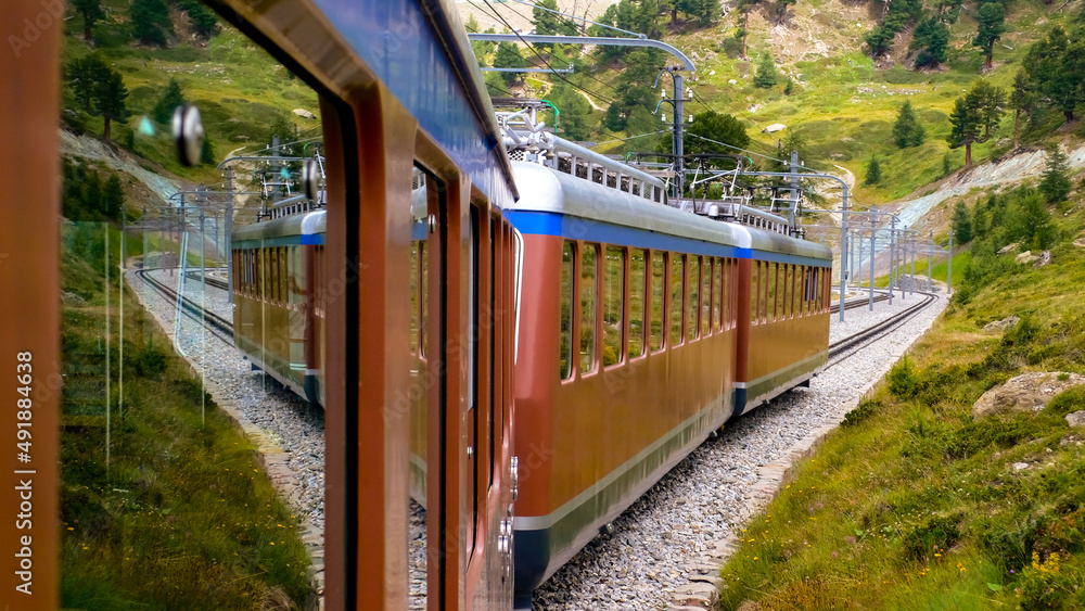 Famous narrow gauge gear train “Gornergrat-Bahn“ descending from ...