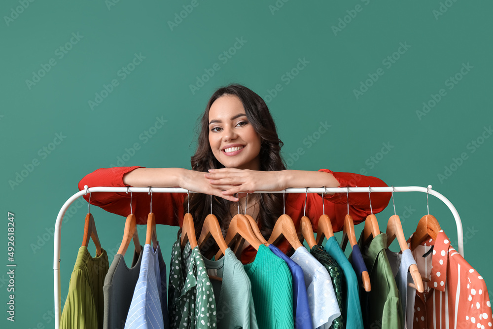 Beautiful young girl near rack with clothes for high school prom on ...