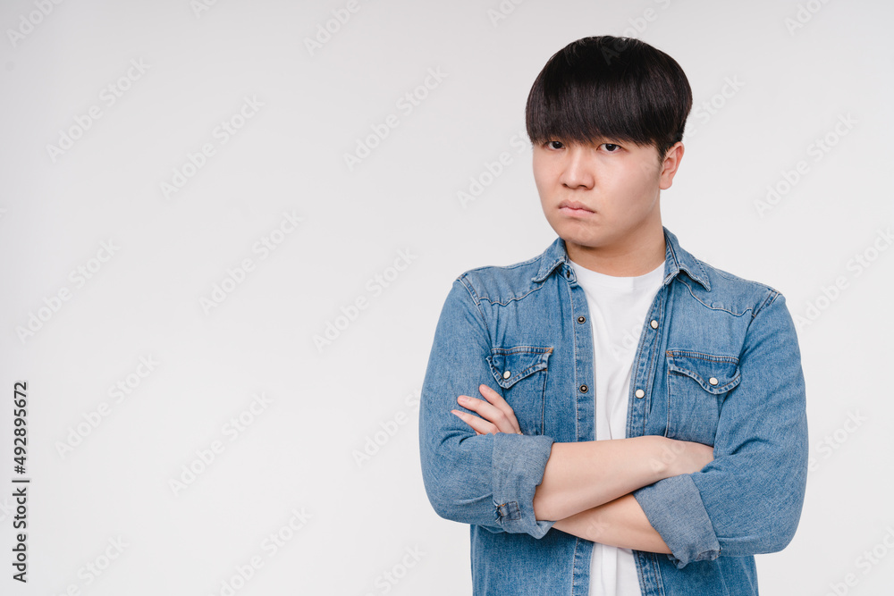 Offended sad angry young asian korean man student boy blowing his lips ...