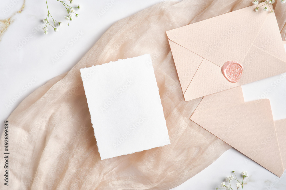 Blank white invitation card with pink envelopes and gypsophila branches ...