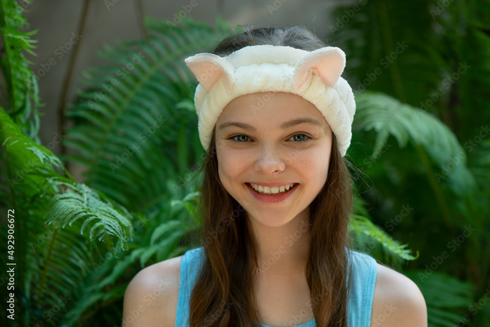 Beautiful little teenage girl with funny cat headband is smiling front ...