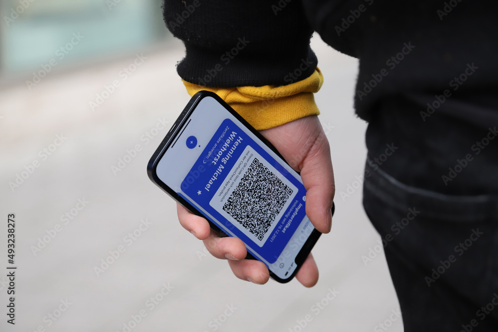 Official German certificate of vaccination on a mobile phone. The name ...