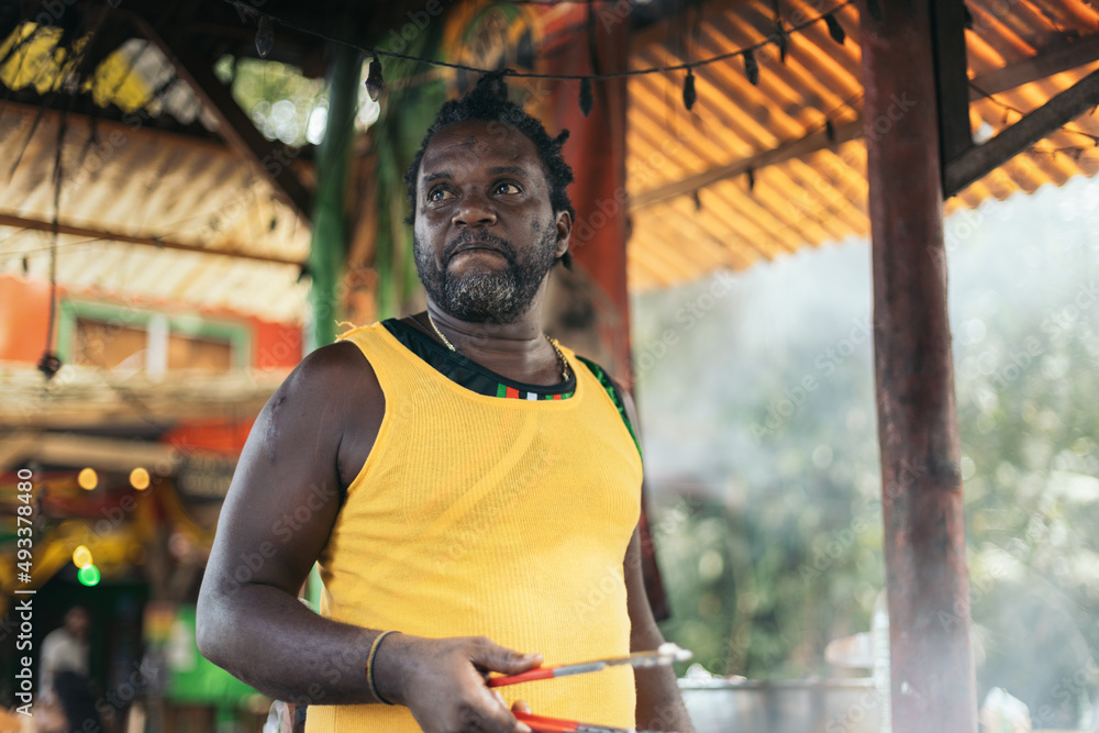 Afro-Caribbean man cooking on a barbeque Stock Photo | Adobe Stock