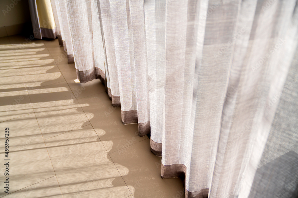 close up white sheer curtain with sun light with shadow shade on wooden ...