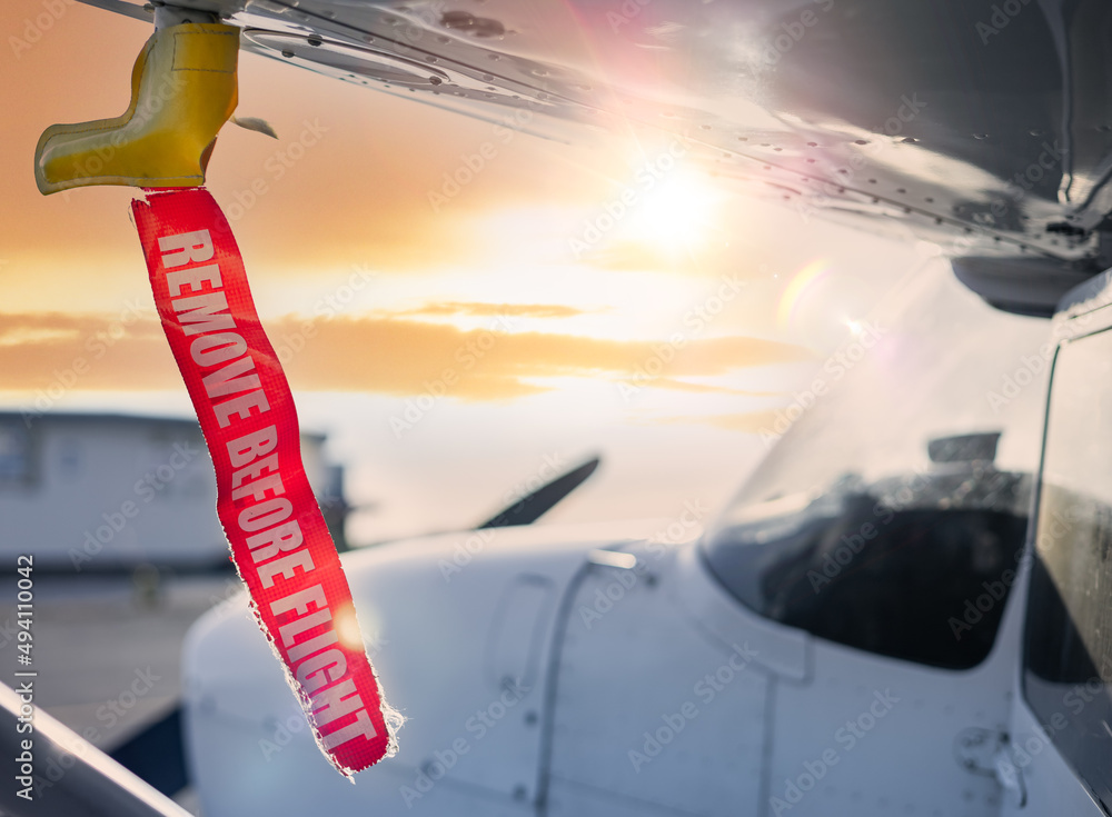 Red tag covering pitot tube with caution words: Remove before flight ...