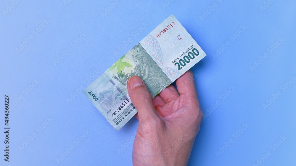 Indonesian Rupiah the official currency of Indonesia. Man's hand is ...