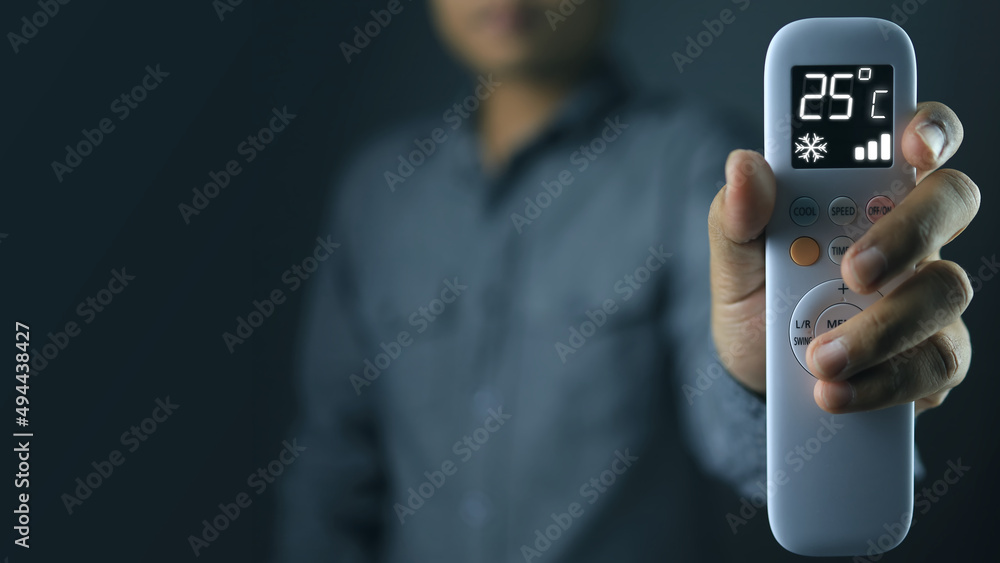 Hand holding the remote control after adjusting the operation factor ...