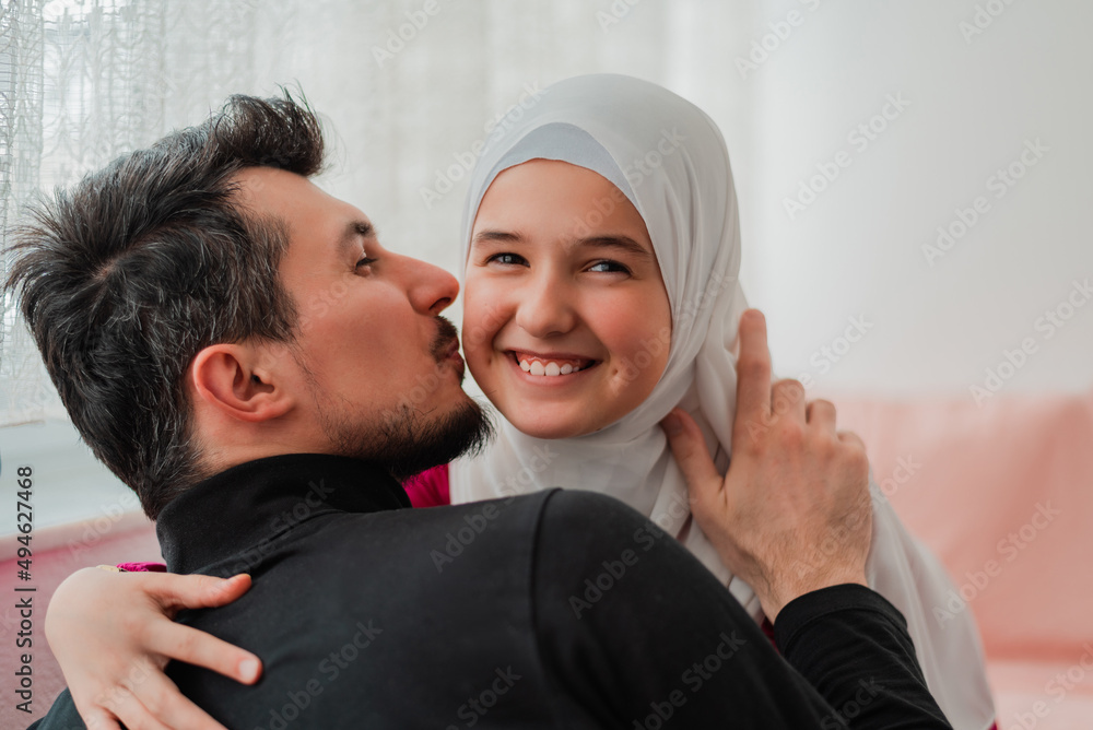 Stock-Foto „Happy Muslim family in the home. Young father kissing child ...