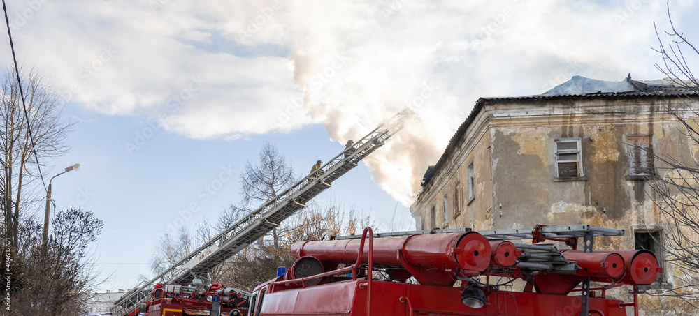 Firefighter works on boom of fire engine. Fireman on sky background ...