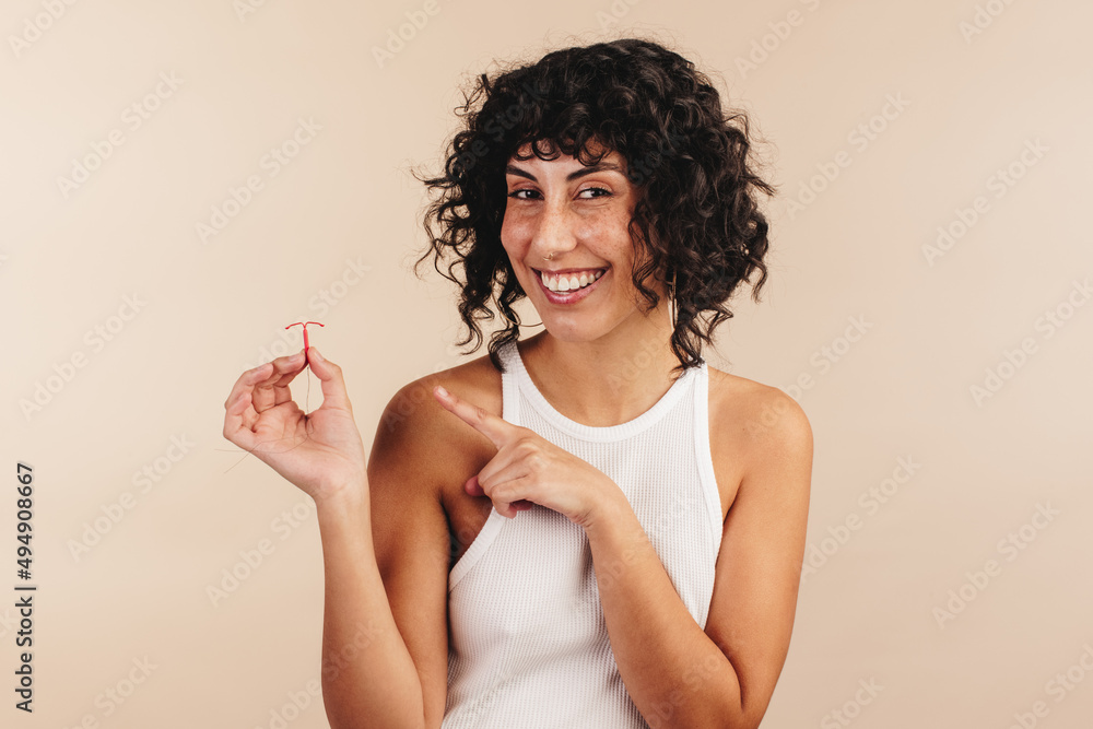 Foto Woman holding the copper IUD in her hand do Stock | Adobe Stock