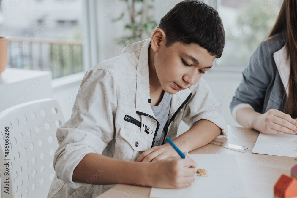Asian boy sitting and drawing in art class. Kid student learning art ...