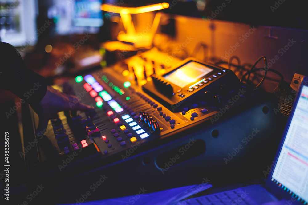 View of lighting technician operator working on mixing console ...