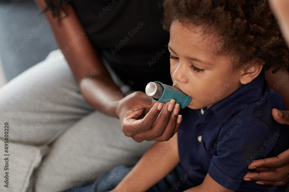 Mother helping little son to use asthma inhaler against allergic attack ...
