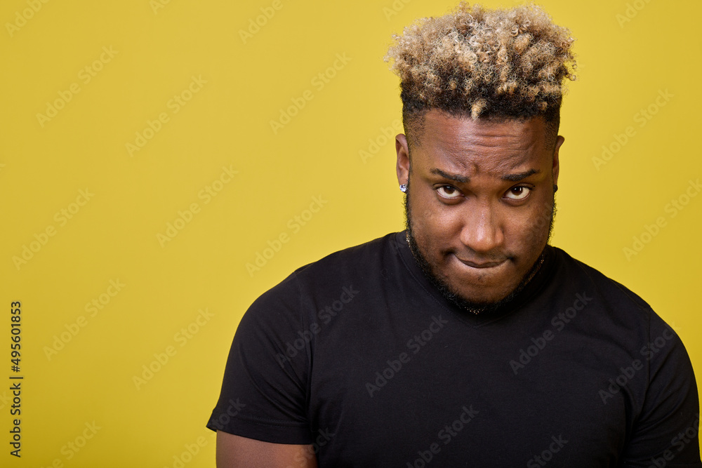 A dark-skinned guy with curly hair looks guiltily pursed by pursing his ...