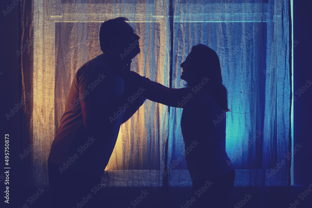 Silhouette of fighting man and woman at night window, domestic violence ...