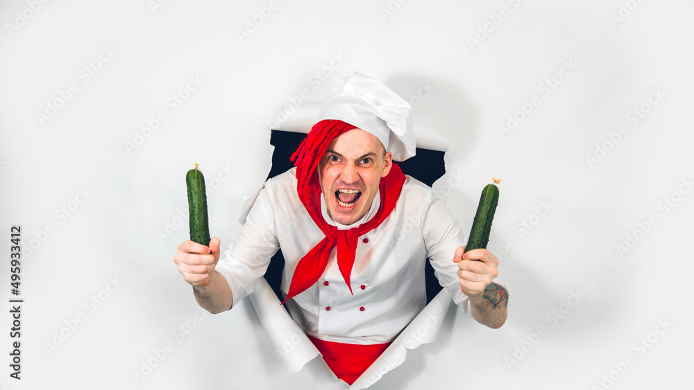 Young insane man dressed as chef with cucumbers. Crazy male cook with ...