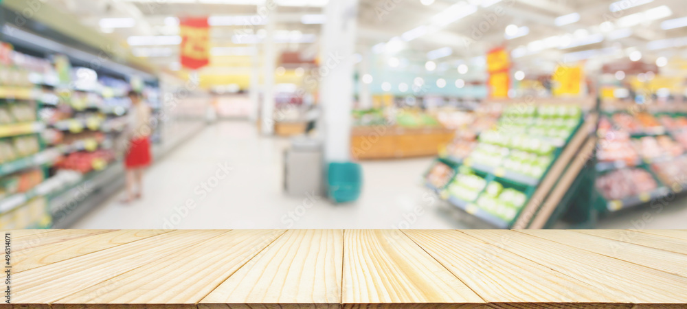 Wood table top with supermarket grocery store blurred defocused ...