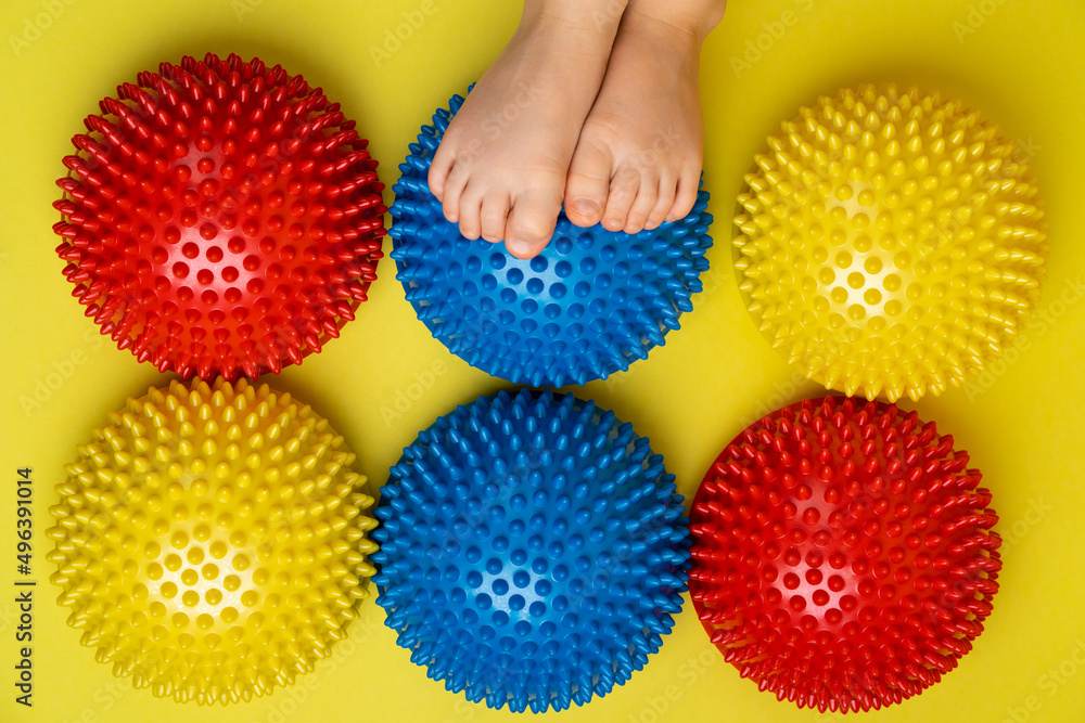 children's feet with a colored balancer on a light yellow background ...