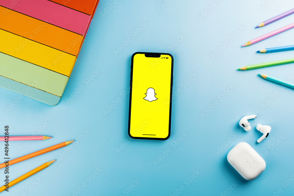 Snapchat app on the smartphone screen. Blue background with school ...