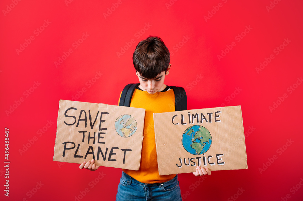 Young teenage holding two cardboard signs that says SAVE THE PLANET and ...