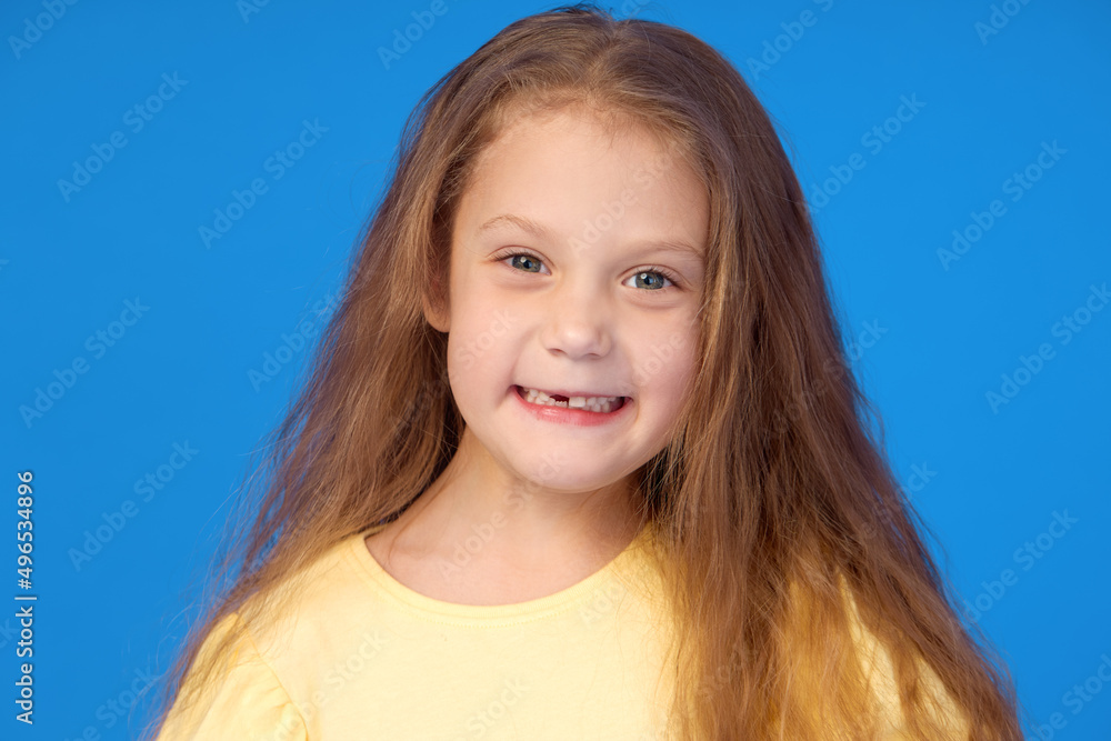 Toothless child. Cute little girl smiles broadly on a blue background ...