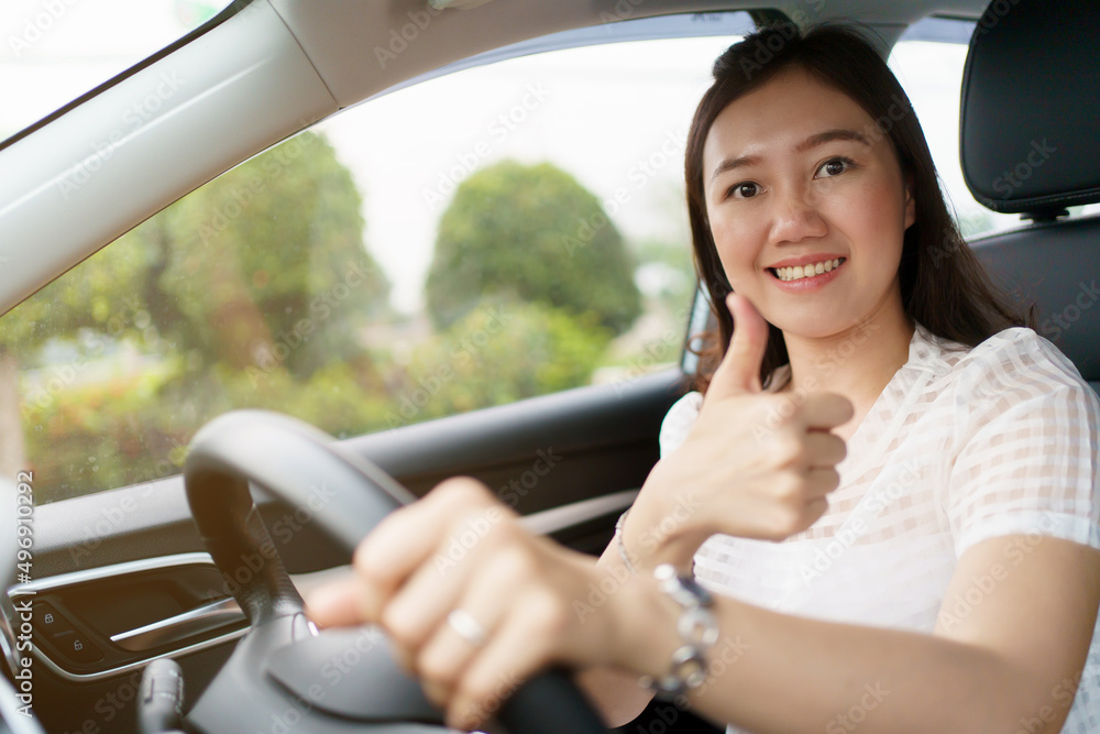 Happy Asian woman driving the electric vehicle - EV car smiling and ...