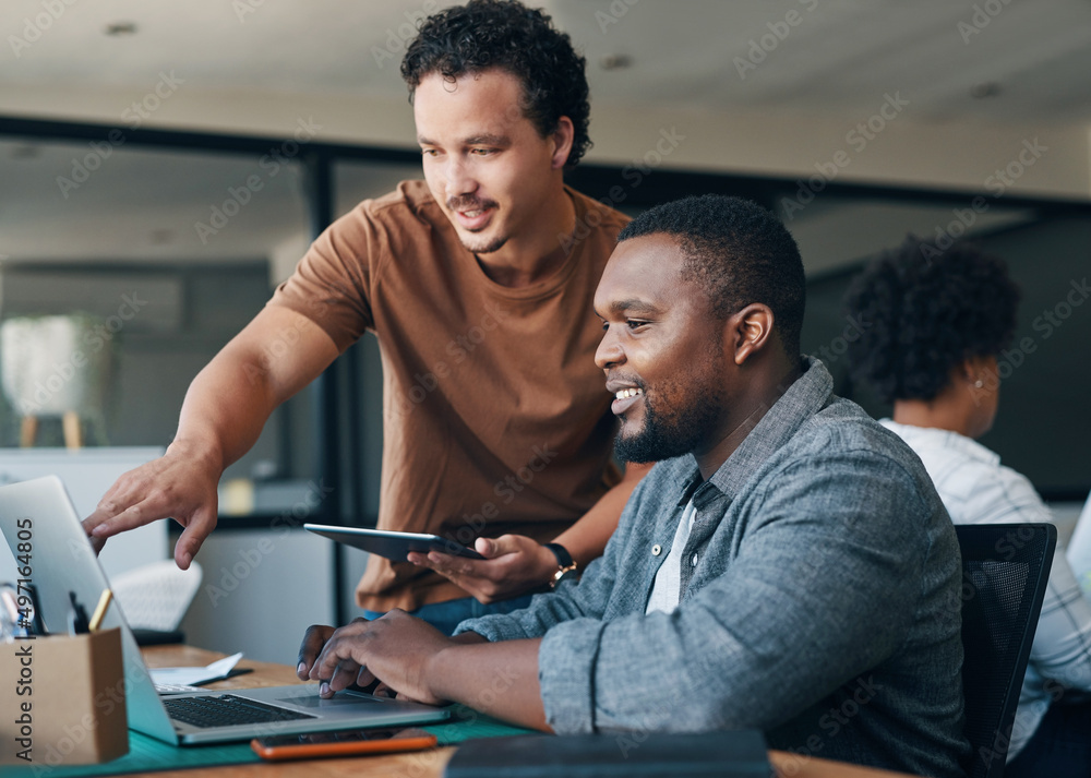 Teamwork makes everything easier. Shot of two young businessmen working ...