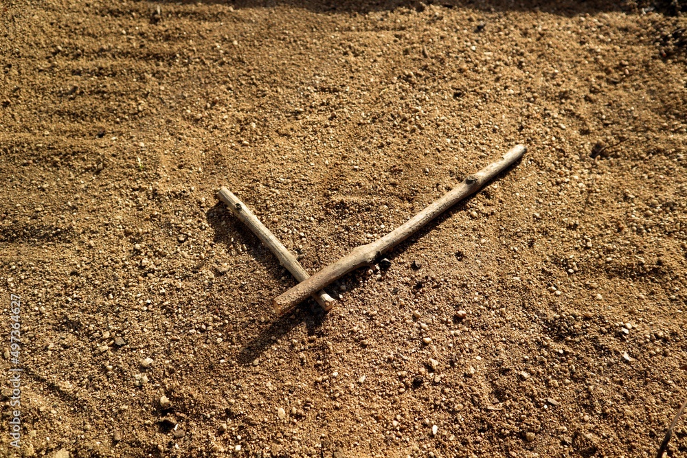 Yes tick mark from small wooden sticks. Symbol of yes on sandy ...