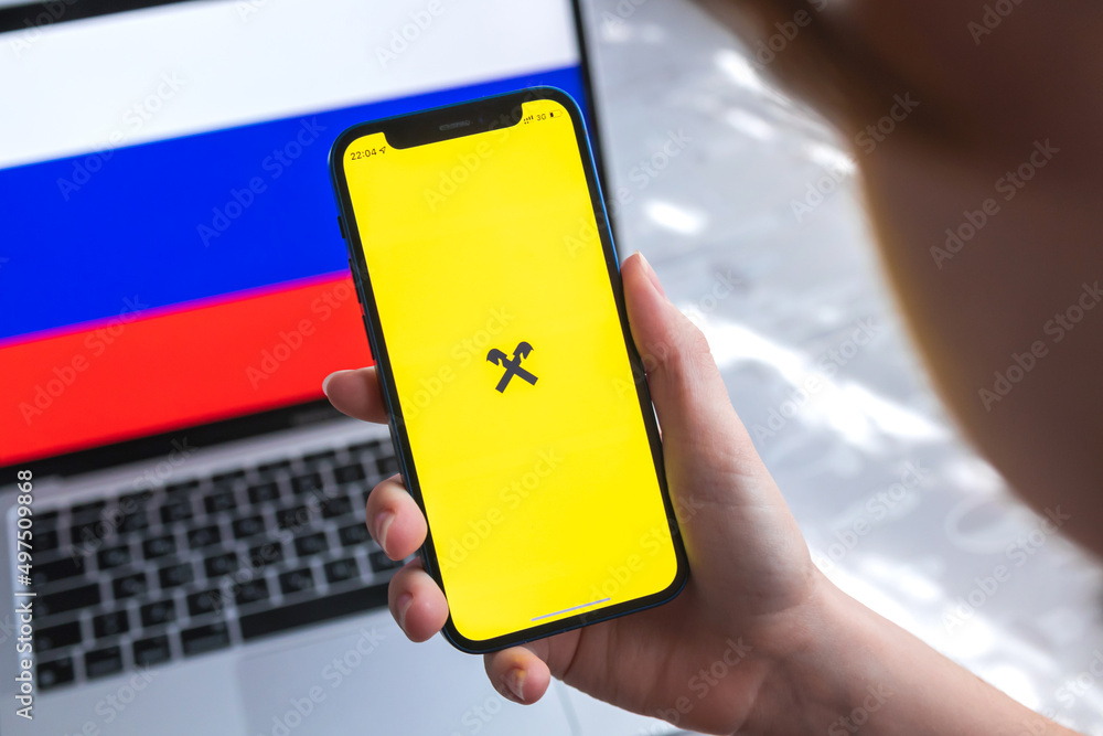 Raiffeisen mobile banking app in Russia. Hand with smartphone, logo on ...