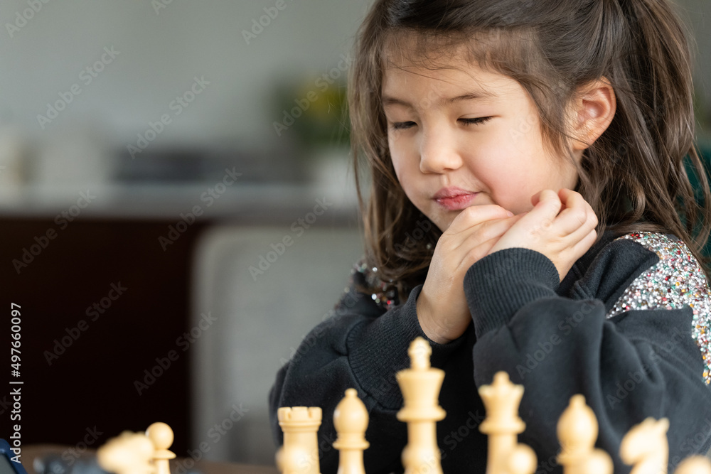 Little girl playing chess Stock Photo | Adobe Stock