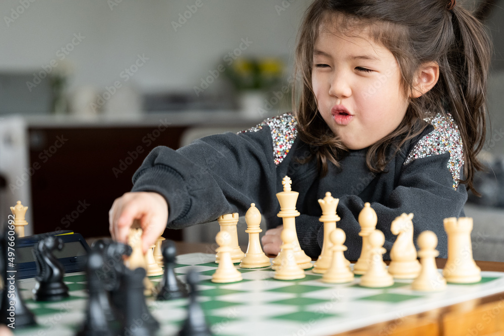 Little girl playing chess Stock Photo | Adobe Stock