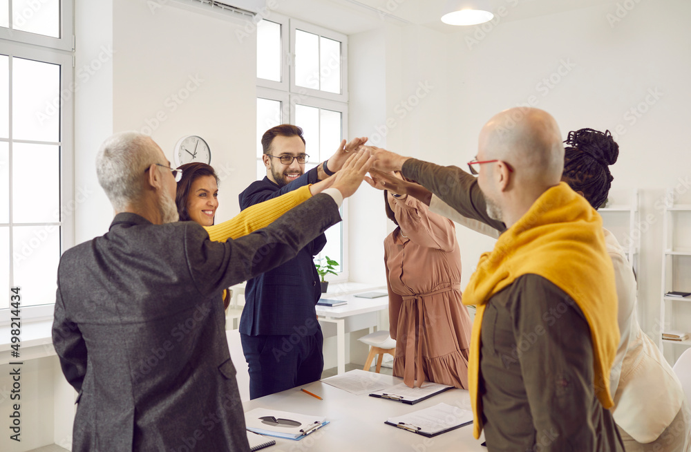 Happy multiethnic business team standing around office table and ...