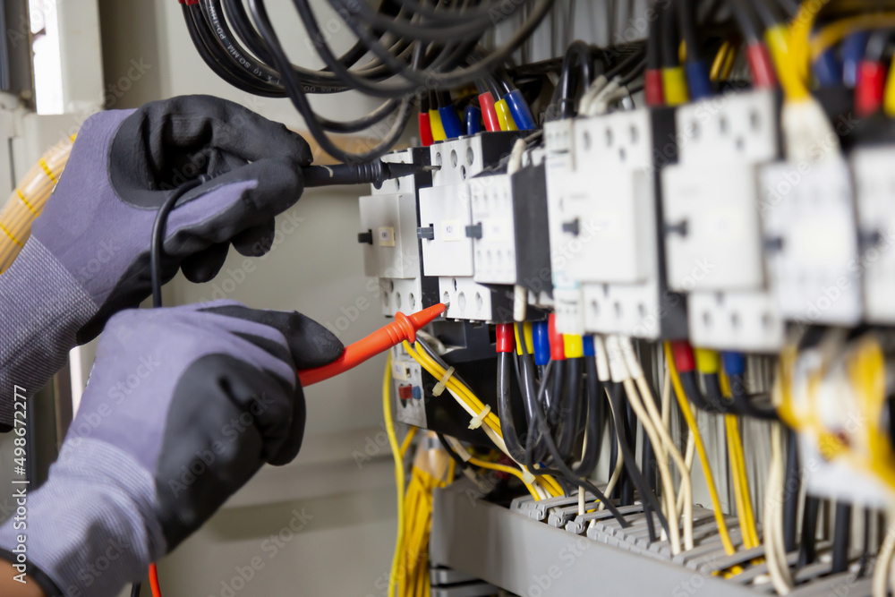 Electrician engineer tests electrical installations and wires on relay ...