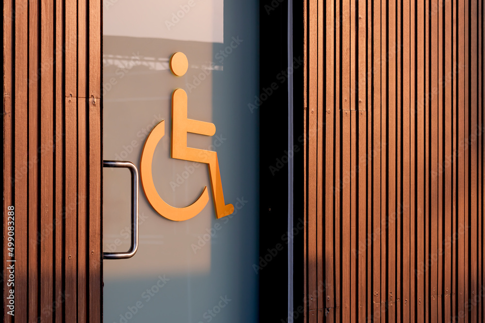 Perspective side view of disabled wheelchair restroom sign on glass ...