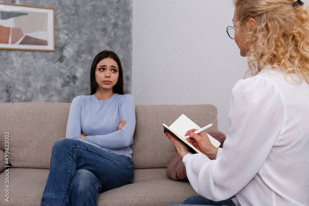 Young woman in distress on a psychological therapy session. A ...