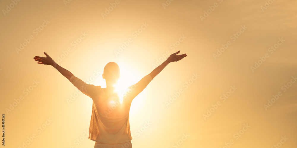 Feelings of hope light. Female lifting her arms up to the golden sky ...