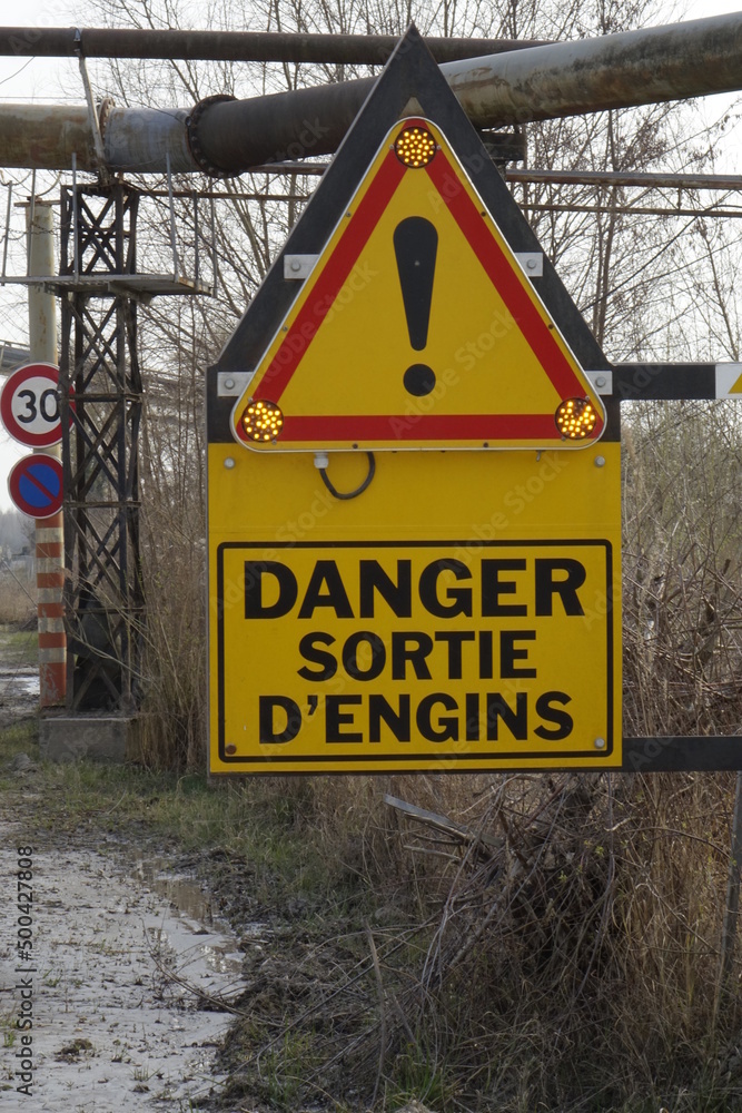 Yellow, red and black French traffic warning sign 'Danger! Exit of ...