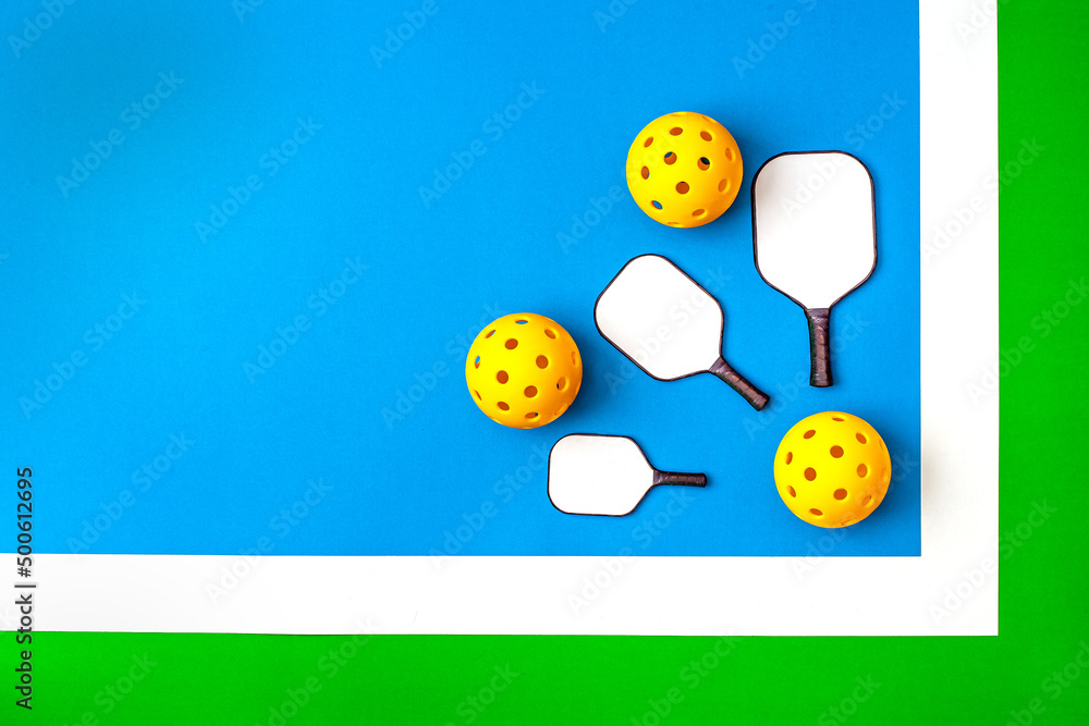 Pickleball display. 3 yellow Pickleballs with mini paddles on a blue ...