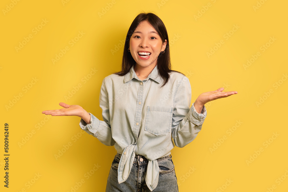 I don't know. Puzzled young Asian woman shrugging shoulders and smiling ...