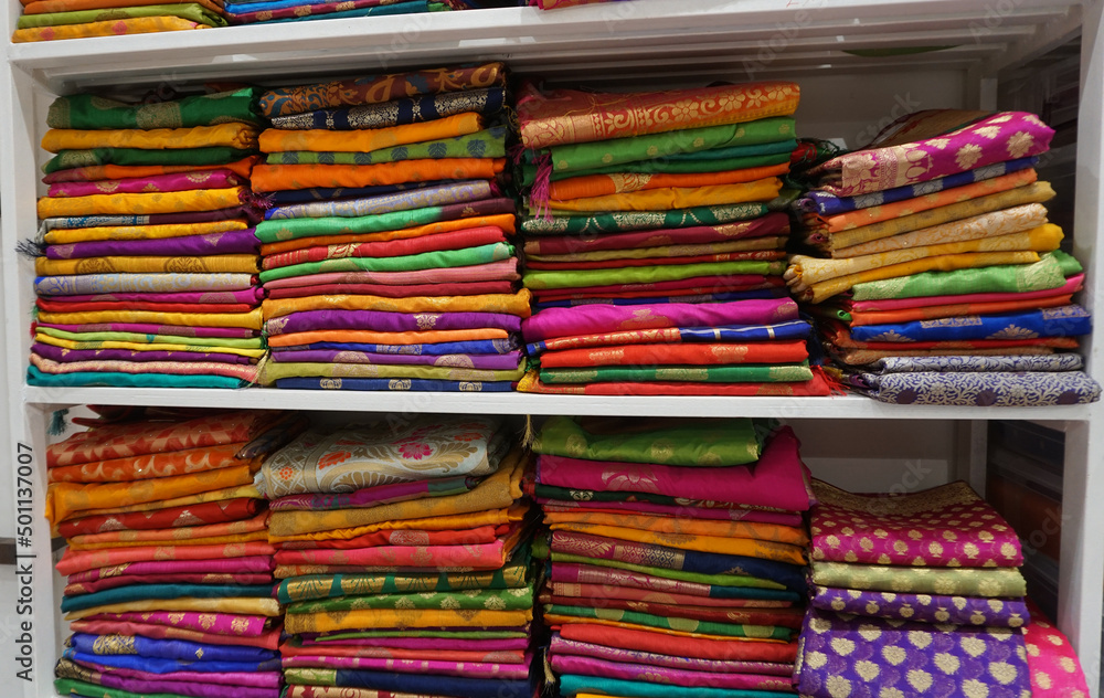 Colorful sarees or saris are arrange on racks and display in a retail ...
