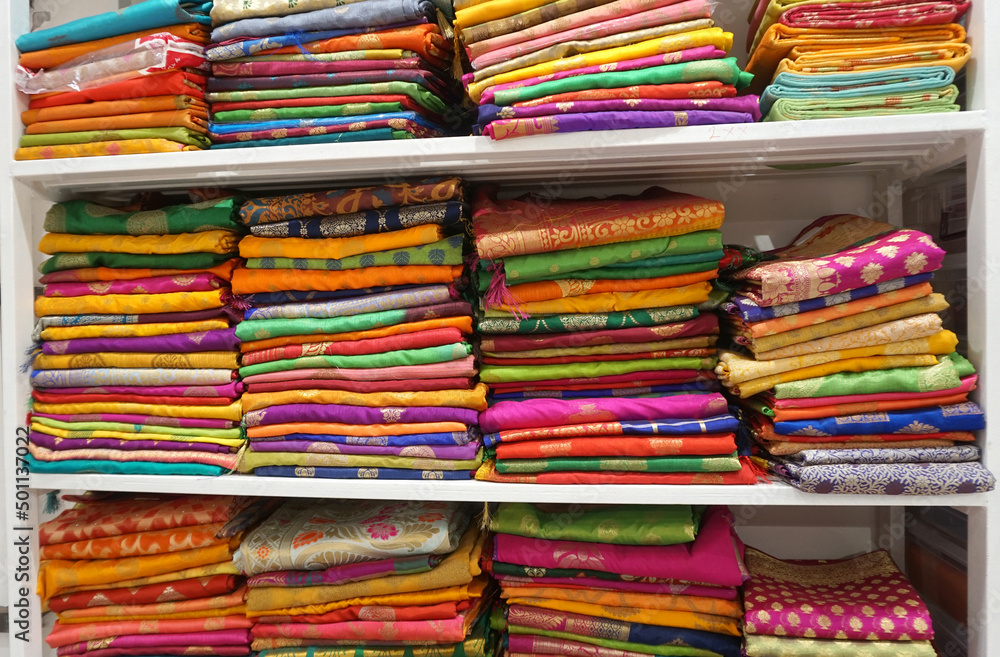 Colorful sarees or saris are arrange on racks and display in a retail ...