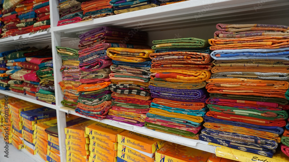 Colorful sarees or saris are arrange on racks and display in a retail ...