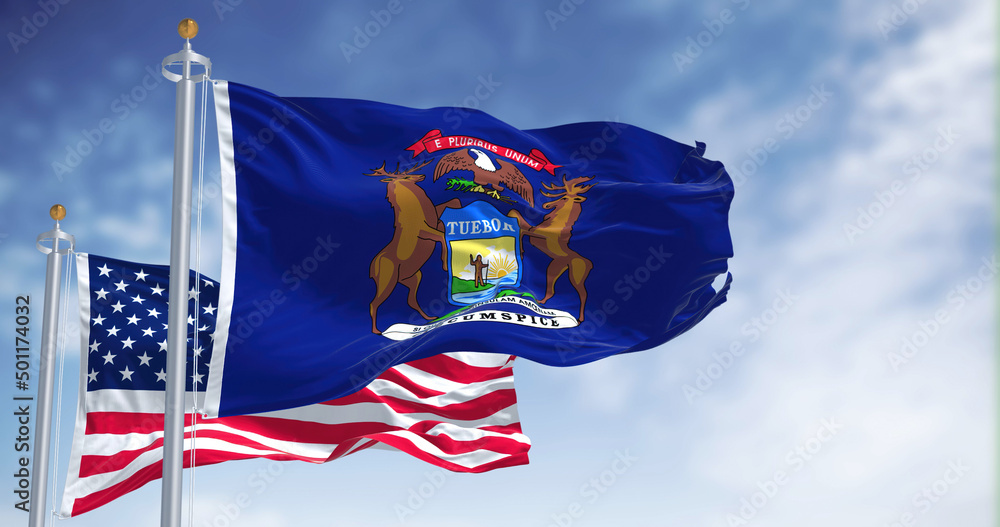 The Michigan state flag waving along with the national flag of the ...